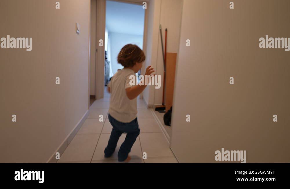 Child playing hide and seek at home. Little boy running indoors hiding ...