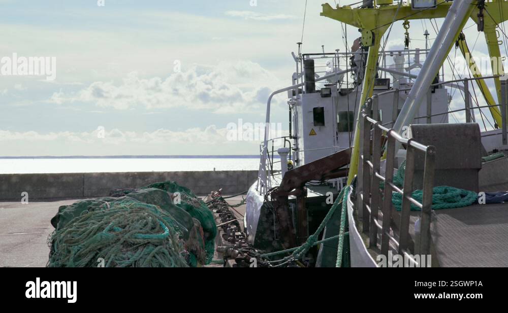 Mooring tug trawl boat docking next to pile of rope swarm of flies in ...