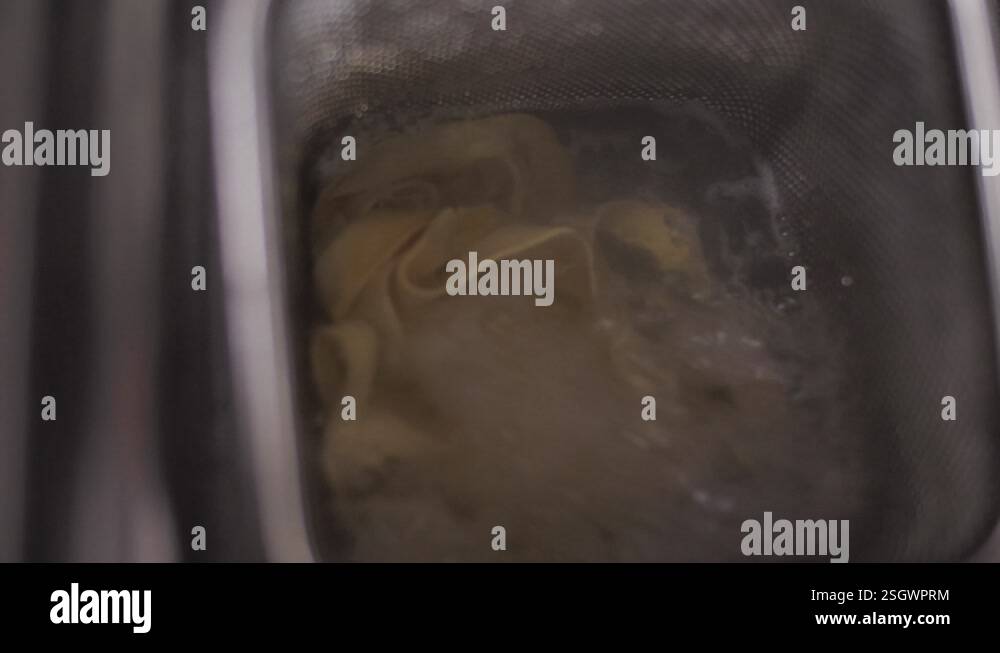 Close up on boiling pasta in sieve in professional pasta boiler Stock ...
