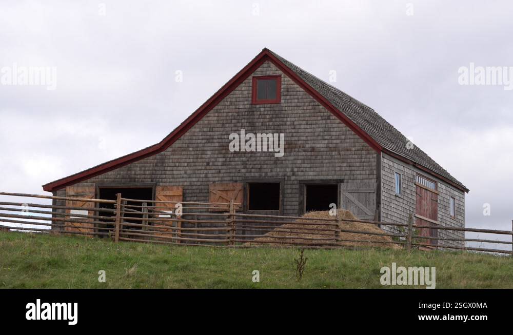 A beautiful barn made with wood on a farm. Behind you can see a cloudy ...