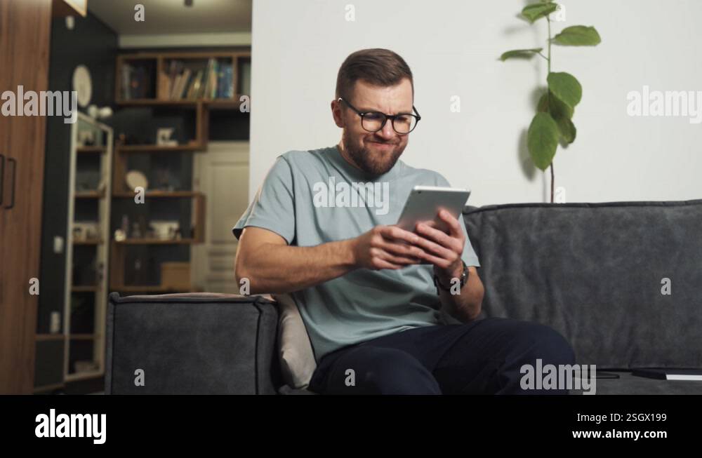 Shocked by what he saw in the tablet, the man begins to get angry and ...