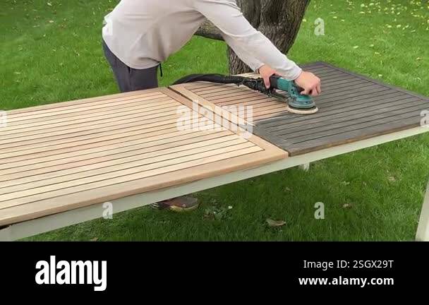 Carpenter sanding teak wood table with orbital power sander, before and ...