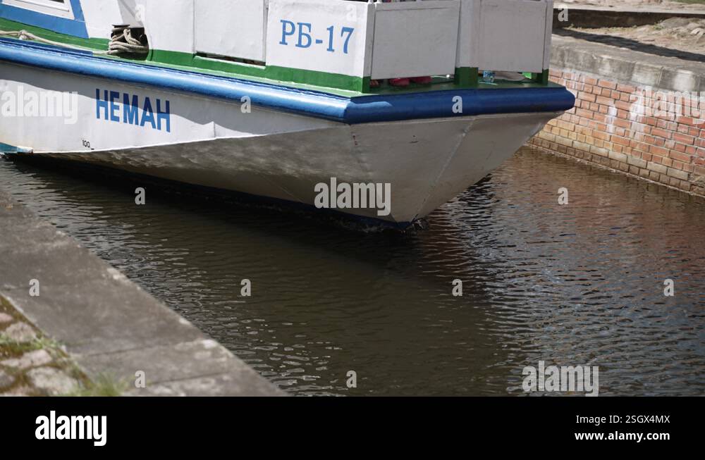 Boat quickly sails behind wooden gate into brick gateway, close-up ...