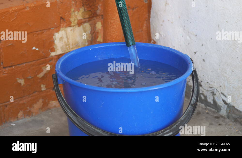 Clear water flows from a hose into a blue bucket Stock Video Footage ...