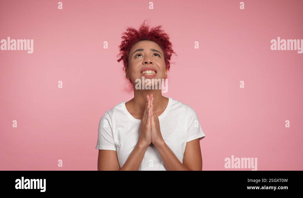 African American woman holds hands folded in prayer, begging God for ...
