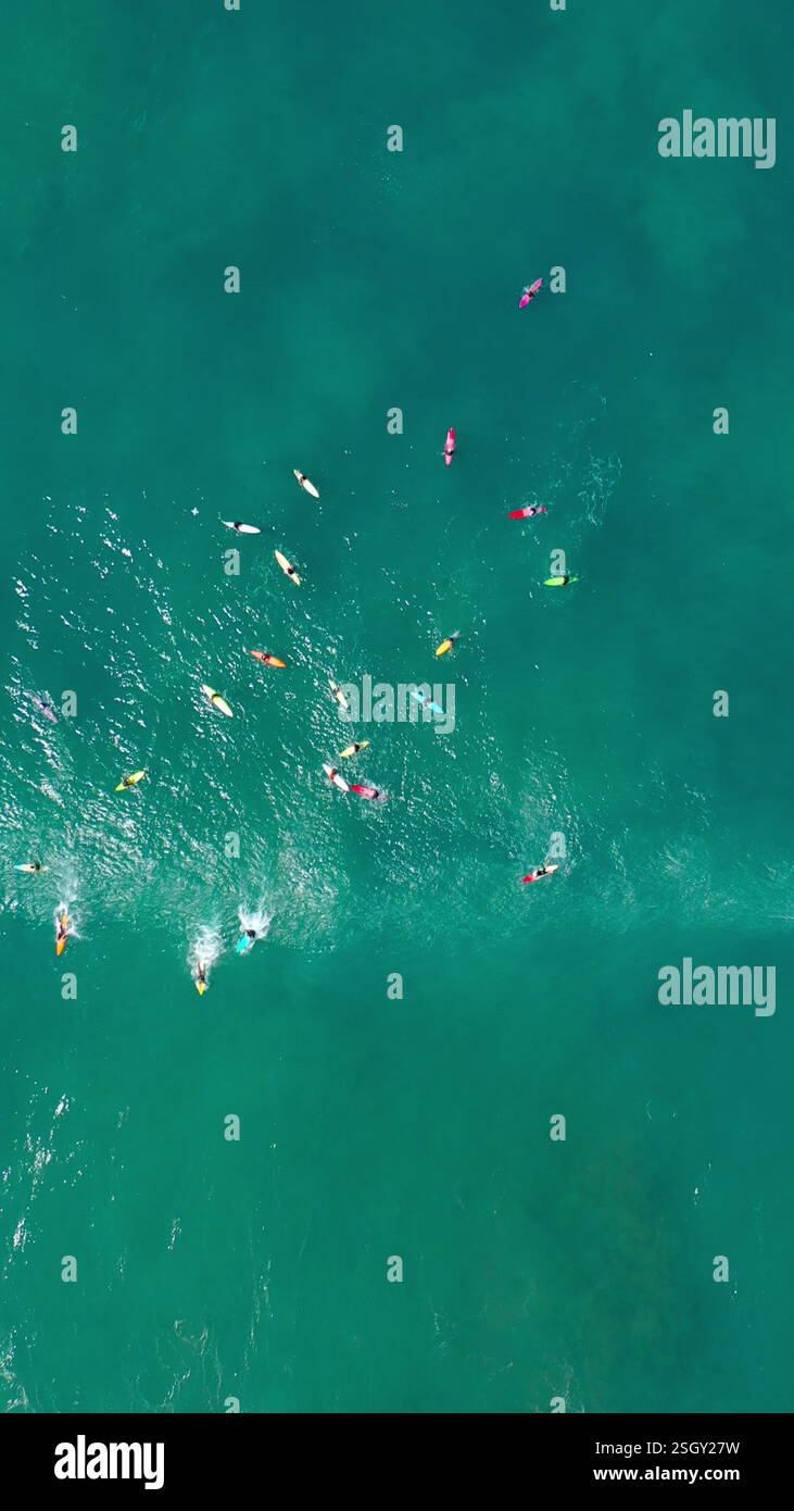 Aerial Top Backward Shot Of Tourists Surfboarding On Wavy Sea At ...