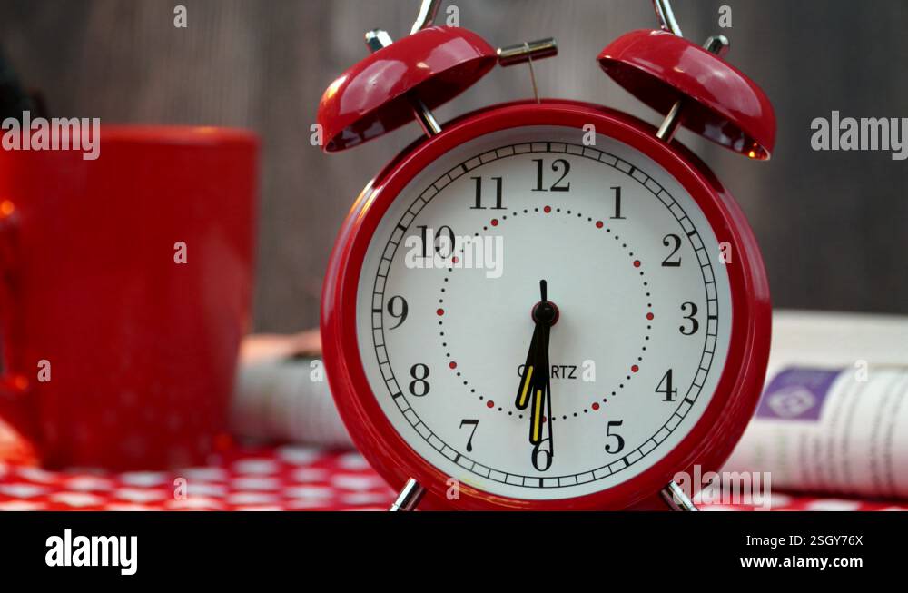 Time lapse of a red alarm clock with coffee and the morning newspaper ...