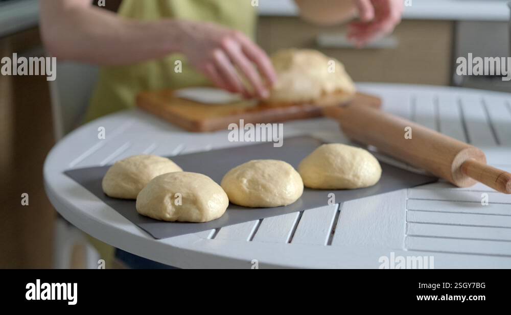 Dough preparation. Baker hand making dough balls on a table in kitchen ...