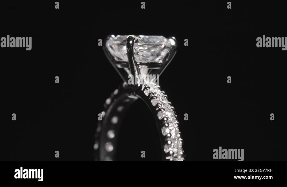 Close up, diamond engagement ring rotating against black studio ...