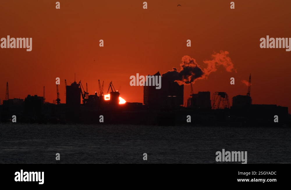 Sun rises behind city skyline, telephoto shot, backlight scene, hight ...