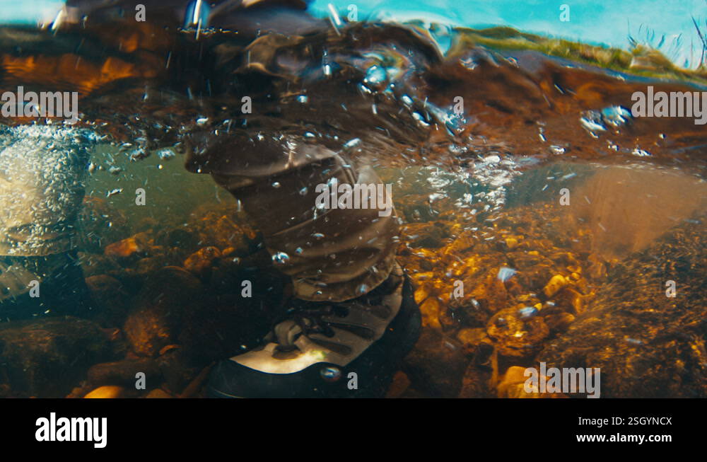 Fisherman underwater view. Angler walks in the wading boots on the ...