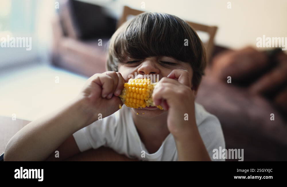 Child eating CORN at home. One little boy snacking nutritious FOOD ...