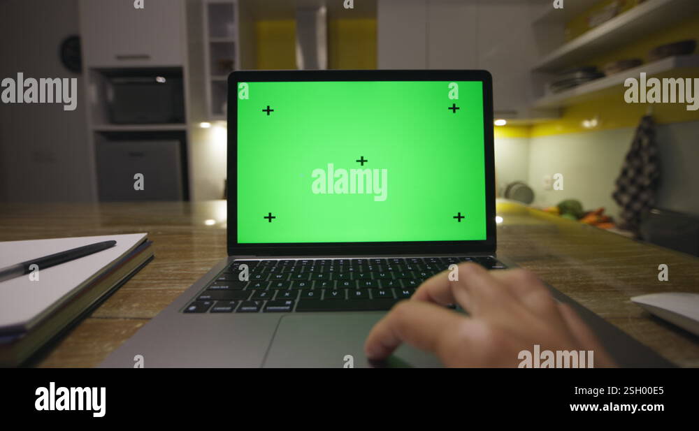 Laptop with green screen. Female hands typing and scrolling on a track ...
