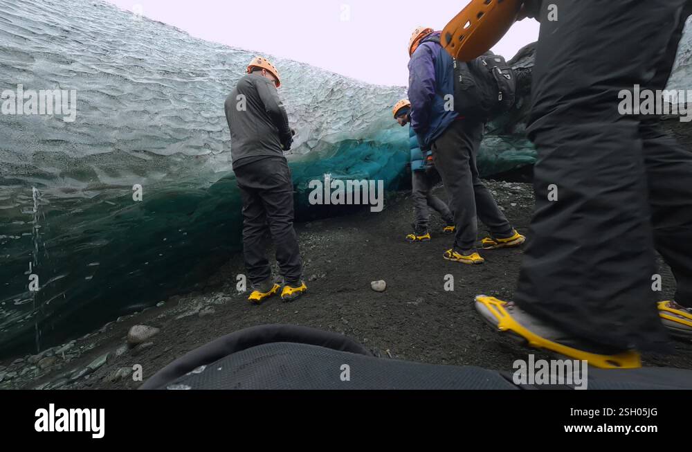 Expedition team heading inside a ice cave in Iceland - static view ...