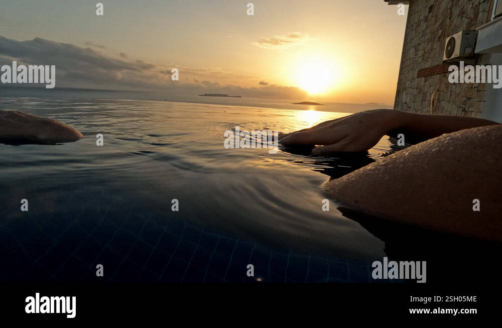 female hands rowing in water in infinity pool in paradise for ...