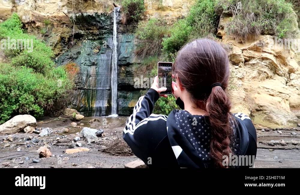 Woman taking photos of a hot springs in Hells Gate National Park, Kenya ...