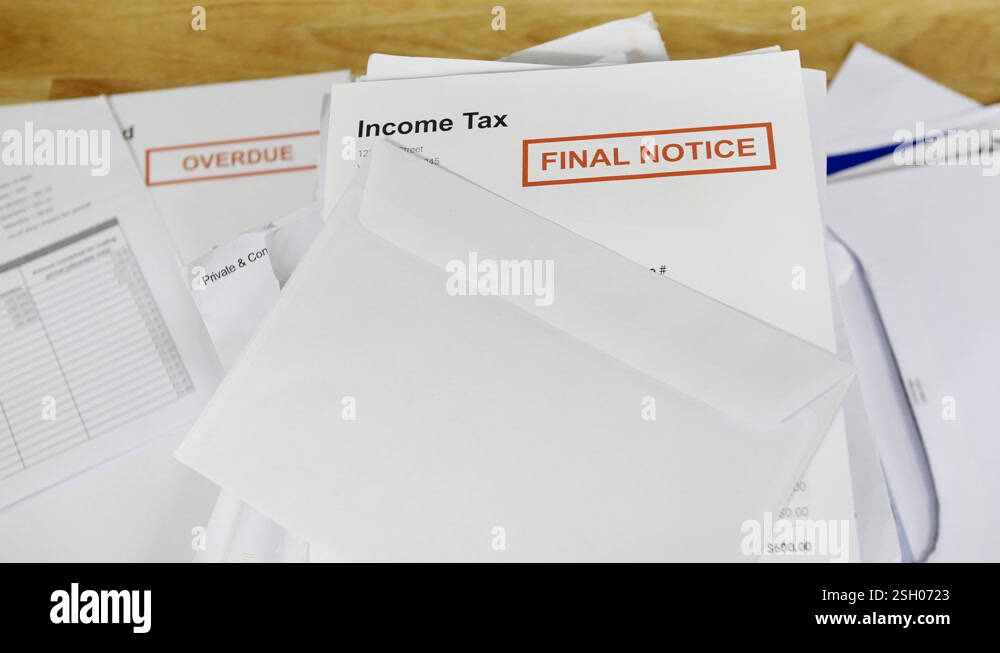 A stack of bills and debts with an income tax final notice letter Stock ...