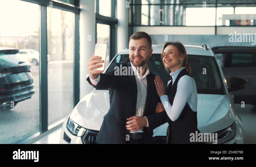 A young solid couple takes a selfie on a smartphone against the ...