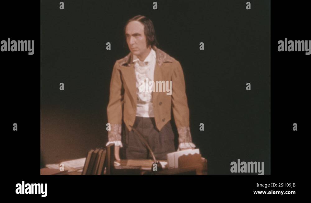 1950s: Clean-shaven Colonial man in short tail coat and cravat speaks ...