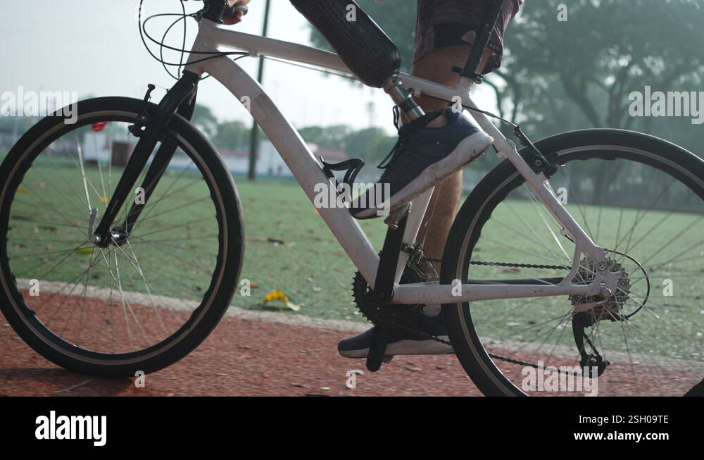 A disabled amputee cyclist riding bicycle with prosthetic leg ...