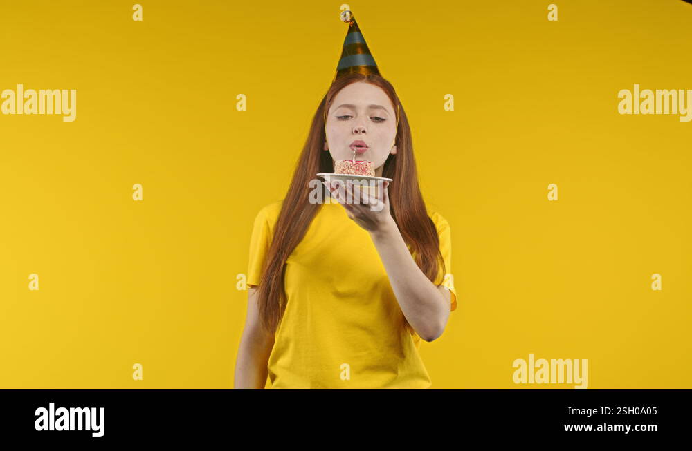 Happy ginger birthday woman making wish - blowing candle on cake. Girl ...