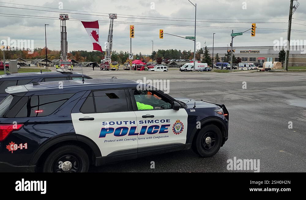 slow sliding shot of two police cars from south Simcoe at the funeral ...