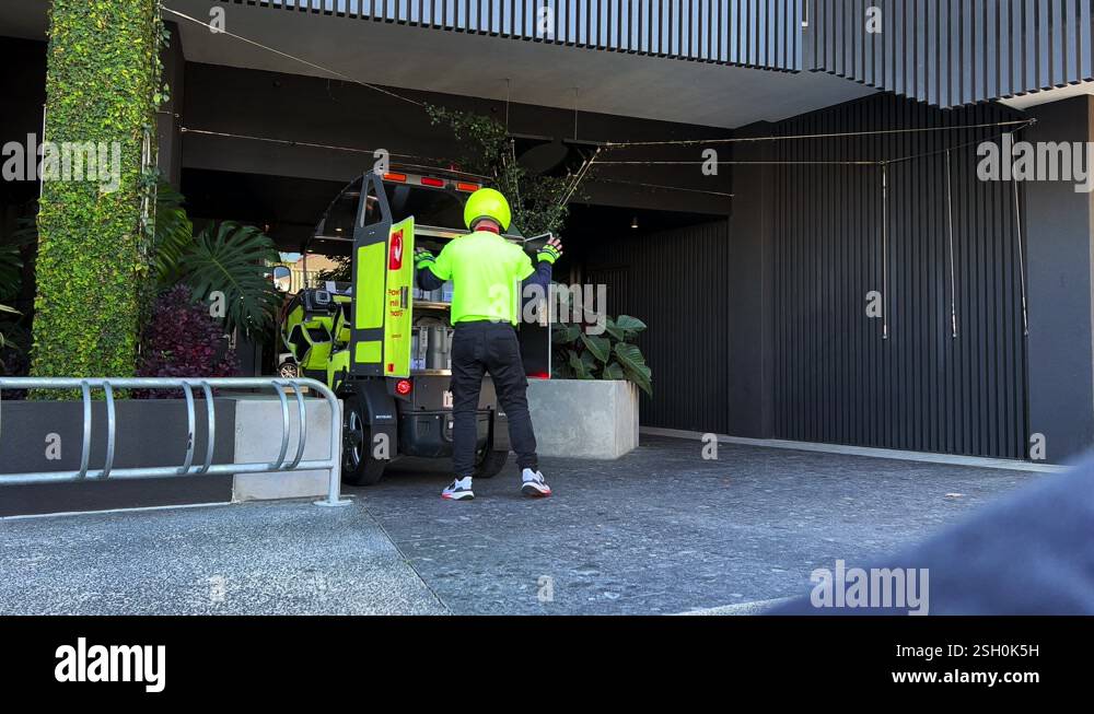 Australia post postman driving battery-operated electric vehicle on the ...