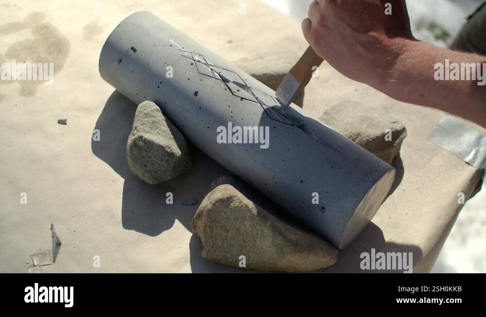 Close up of chipping and hammering out a crack shape in a concrete ...