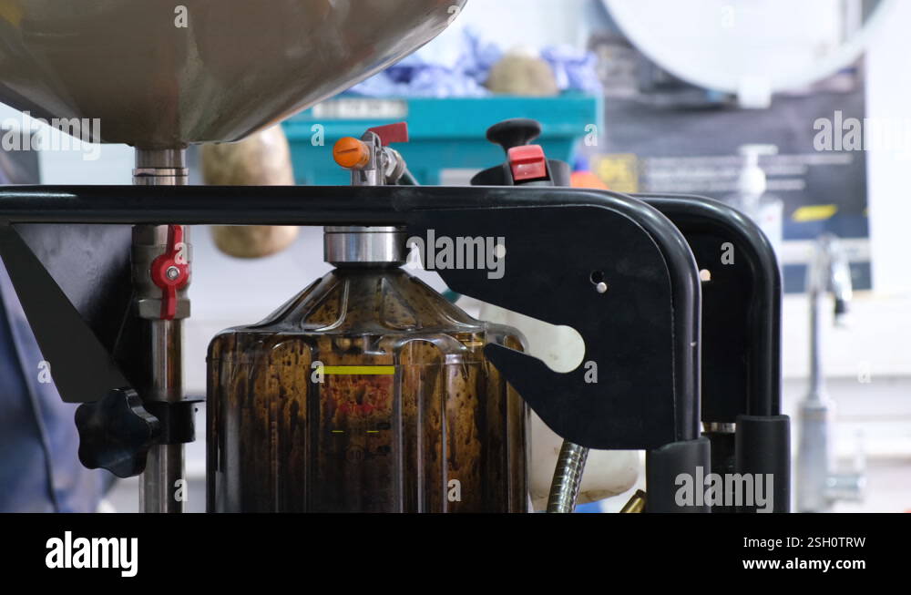 Change engine oil. Draining the old oil from the car into a special ...