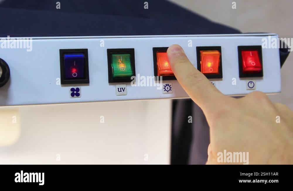 A man's hand turns on and off the buttons that illuminate the panel ...