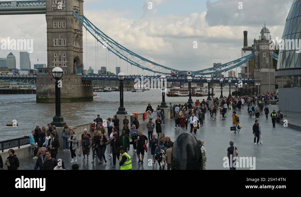A Crowd Of People Walk Past The Tower Bridge And Dome Building In London Stock Video Footage - Alamy
