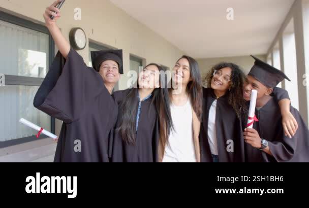 Diverse group of graduates celebrate their achievement. They are ...