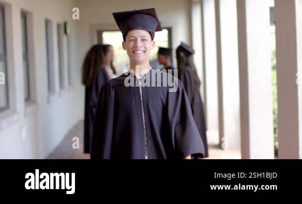 Proud teenage biracial boy celebrates graduation at high school. His ...