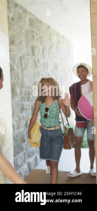 Vertical video: Arriving at home, group of friends greeting each other ...