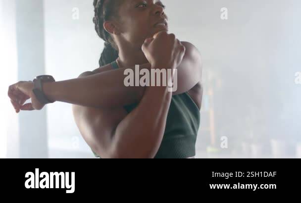 Stretching arms, strong fit woman in gym wearing fitness attire, preparing for workout. exercise ...