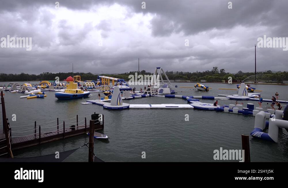 Excited kids playing on inflatable floating aquapark obstacle course ...