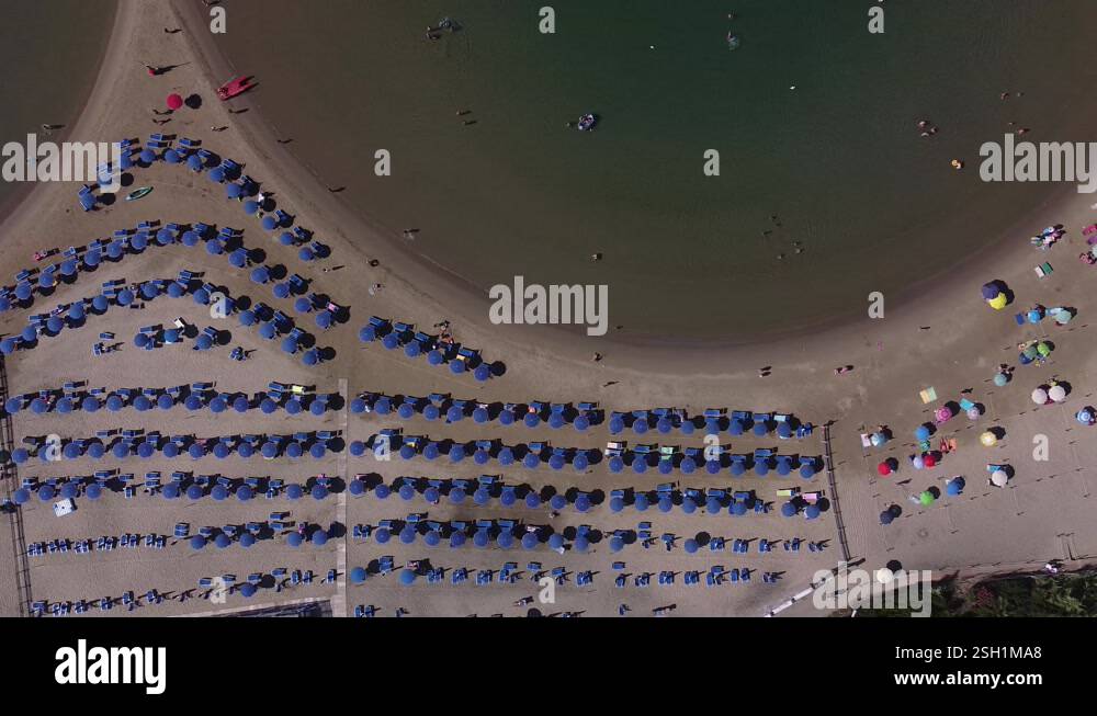 Lines of sunbed and umbrellas on Italy coastline, aerial top down view ...