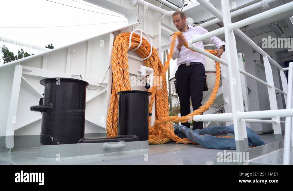 Captain preparing mooring rope onboard for use onboard passenger ship ...