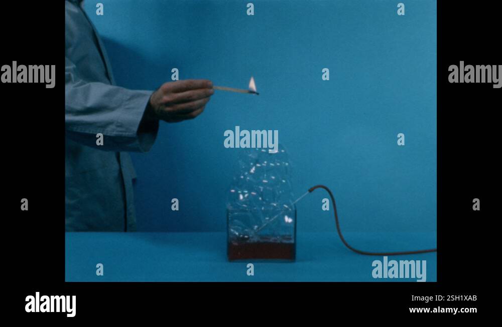 1950s: Man wears lab coat, helium tank hose blows bubbles in container ...