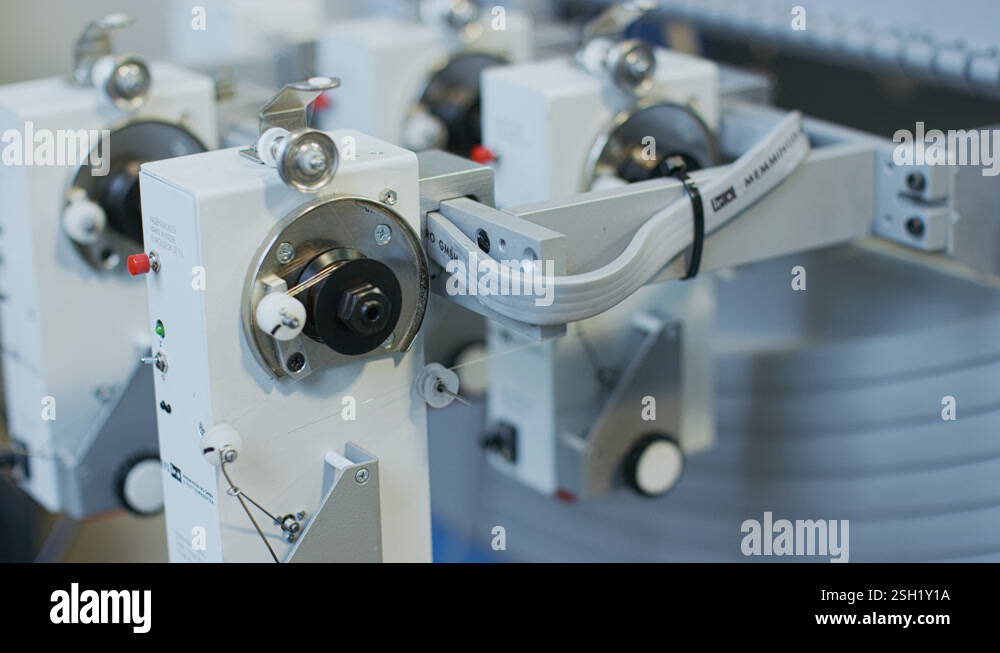 Automated industrial machinery coiling up copper metal wire around the ...