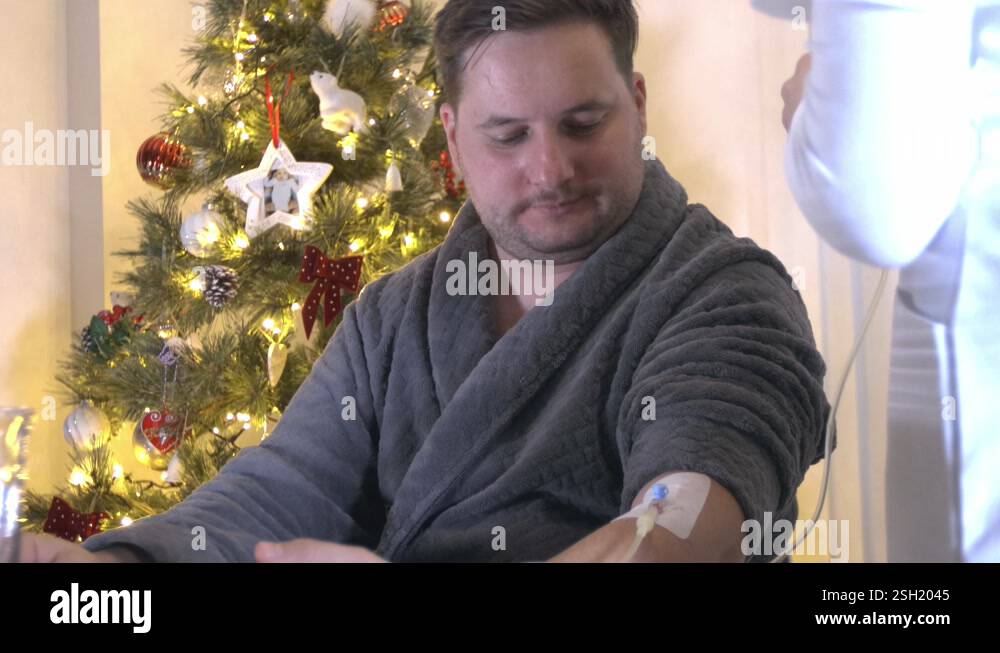 nurse setting dextrose saline solution IV drip on caucasian male ...