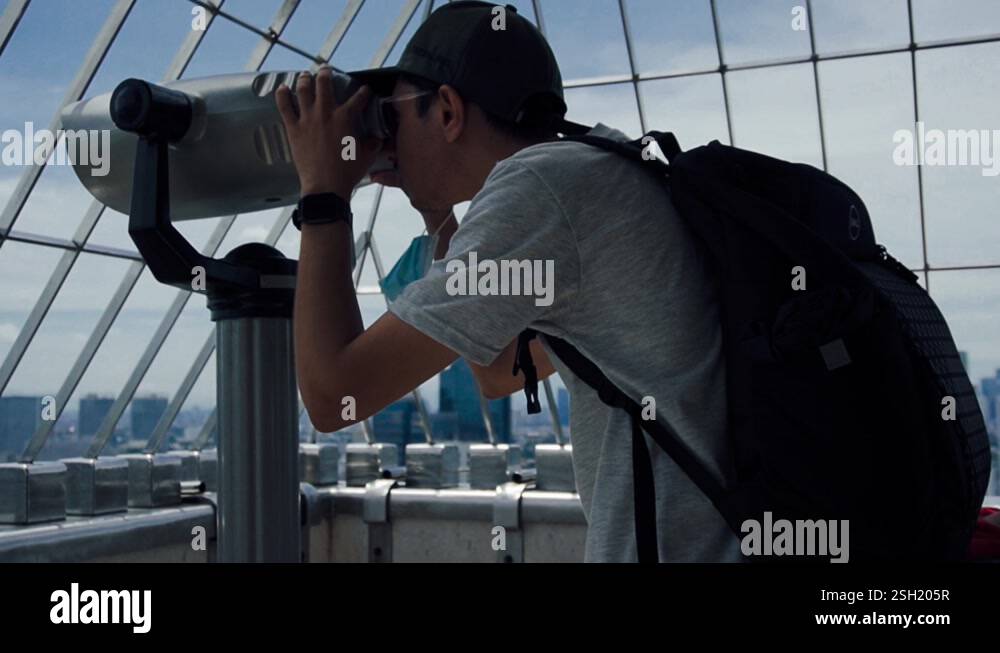 A person looking through the tower viewer binoculars in Jakarta ...