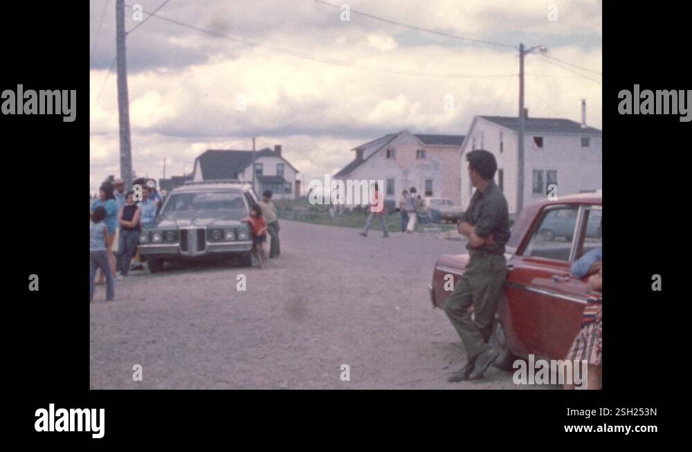 Canada 1970s: Indigenous people wait in a line in a village. Fisherman ...