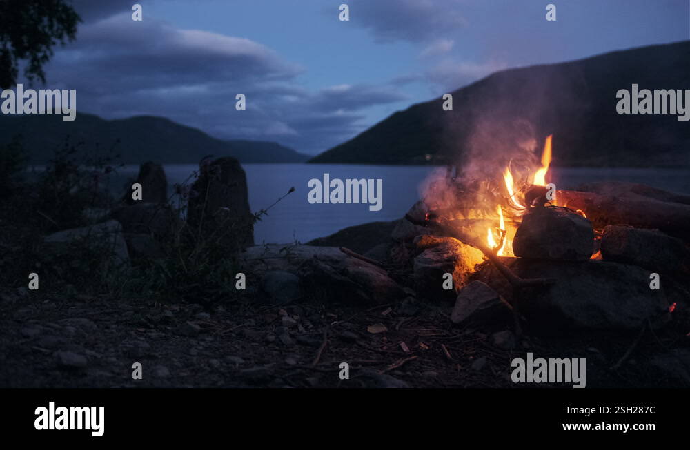 Big bonfire at the beach by a lake in Norway on midsummer night party ...