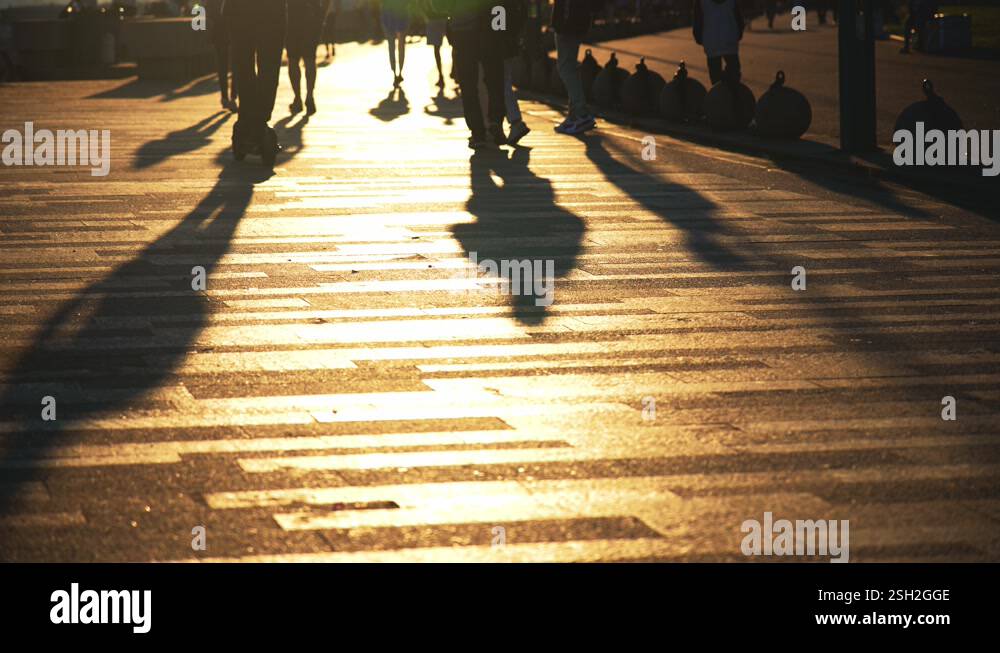On wooden road there legs, shadows and silhouettes of people walking ...