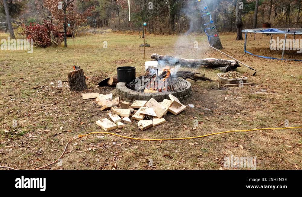 Burning wood waste or cuts from planks and boards in the fire pit Stock ...