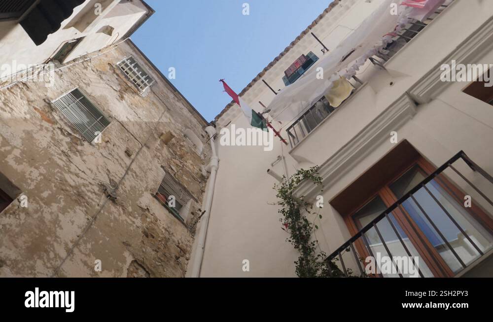 Italian flag wave on building side in Formia city, view from bellow ...