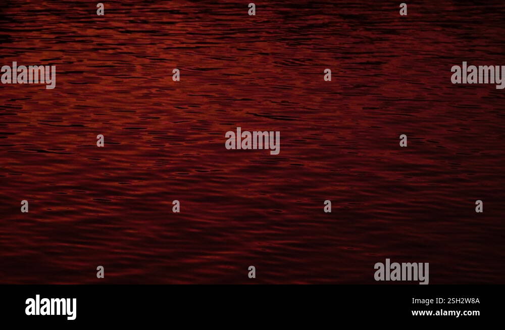Abstract red sunset dusk reflection on rippling lake water, slow motion ...