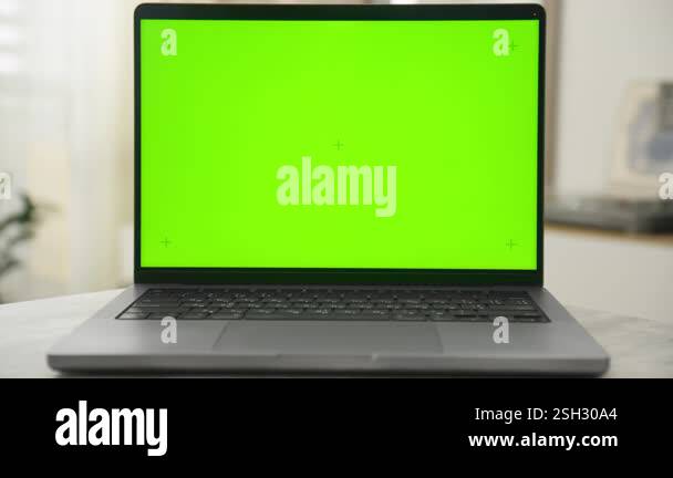 A cinematic dolly zoom shot of a modern laptop with a green screen ...