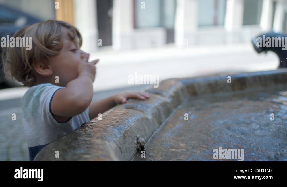 Child drinks from public fountain in urban street in Europe Stock Video ...